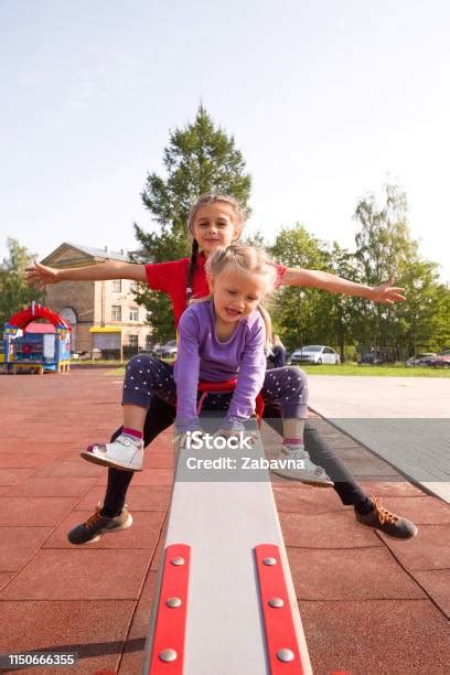 두 행복 한 웃는 백인 여자 놀이터에 재미 타고 시 소 팔 뻗어 수직 2명에 대한 스톡 사진 및 기타 이미지 2명 걷기 공원 Istock