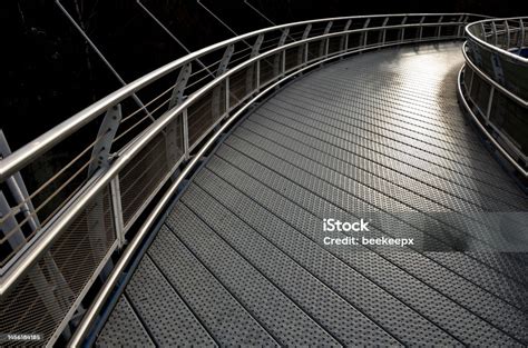 구멍이 뚫린 금속 바닥이 있는 계단과 넓은 보행자 다리 원형 구멍이있는 아연 도금 판금 아치에있는 배와 같은 흰색 난간 광택 스테인레스 스틸 파이프로 만든 난간 0명에 대한