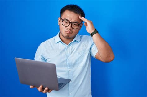 Chinese Young Man Using Computer Laptop Worried And Stressed About A