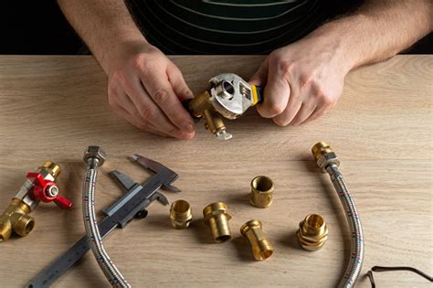 배관공은 배관 렌치로 밸브에 맞는 황동을 조입니다 주인의 손이 닫힙니다 가정 주방에 대한 스톡 사진 및 기타 이미지 가정 주방 가정의 방 강철 Istock