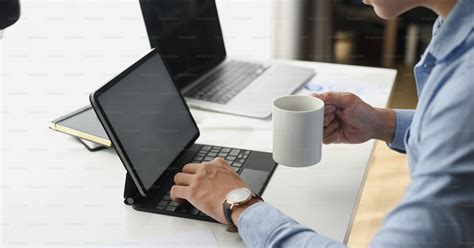 커피를 마시고 사무실 책상에서 그래프 정보 다이어그램이 있는 태블릿 컴퓨터에서 작업하는 사업가의 잘린 샷 사진 Unsplash의 컴퓨터 키보드 이미지