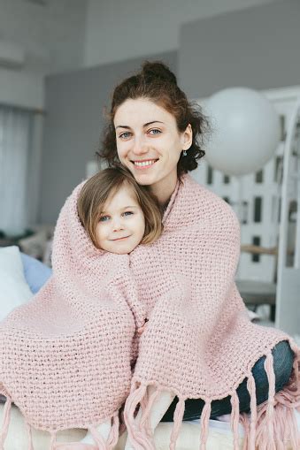 엄마와 그녀의 작은 딸 포옹 웃 고 분홍색 담요에 덮여 나무 침대에 앉아 공생 행복 한 가족의 날 개념입니다 파스텔에 대한 스톡 사진 및 기타 이미지 Istock