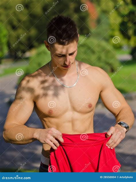 Giovane Muscolare Che Si Spoglia In Una Sosta Fotografia Stock Immagine Di Corpo Spogliare