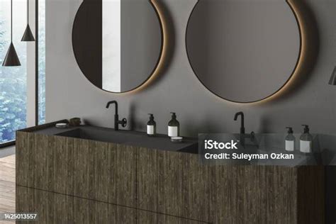 회색 벽 나무 바닥 더블 싱크대 및 두 개의 둥근 거울이있는 현대적인 욕실의 구석 흐릿한 보기가 있는 창입니다 3d 렌더링 0명에 대한 스톡 사진 및 기타 이미지 Istock