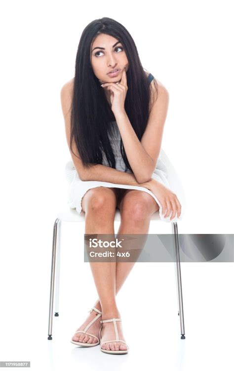 전체 길이 전면 1819 세 아름다운 검은 머리 긴 머리 라틴 아메리카와 히스패닉 민족 여성 젊은 여성 십대 소녀 앉아 지루함 좌절 앉아 흰색 배경 착용 드레스 앞에 휴식