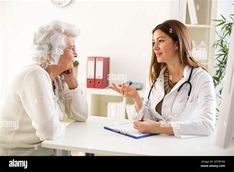 Doctor Explaining Diagnosis To His Female Patient In Hospital Stock