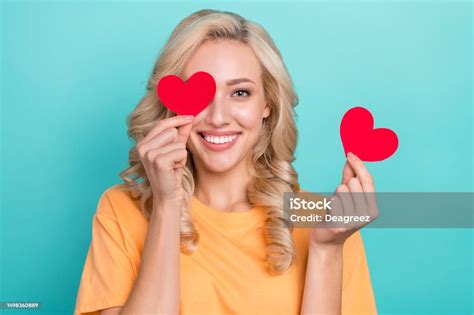 좋은 분위기의 사람의 초상화는 세련된 티셔츠를 입고 손가락은 빨간 종이 하트를 들고 엽서는 청록색 배경에 고립된 눈을 덮는다 18 19세에 대한 스톡 사진 및 기타 이미지