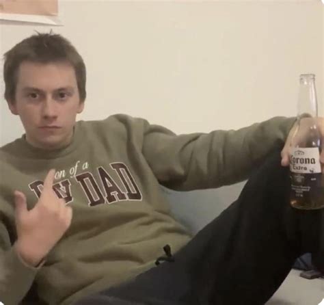 Picture Of The Guy Laying Leaning On The Bed Holding A Drink And