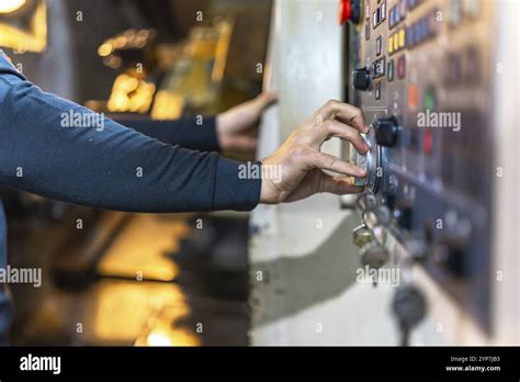 Side View Of The Hands Of A Male Caucasian Worker Using Control Panel Of Lathe Machine In Cnc