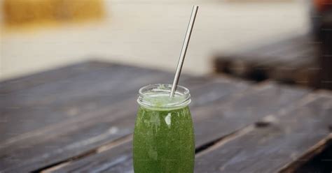 길거리 음식 축제에서 나무 테이블에 금속 재사용 가능한 짚이 있는 유리 항아리에 담긴 건강한 시금치 스무디 폐기물 제로 개념 더운 여름날 상쾌한 음료 사진