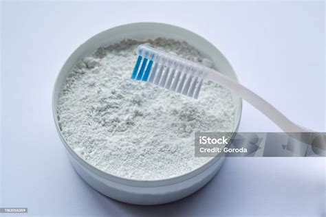 파란색 강모가있는 흰색 칫솔과 흰색 배경에 흰색의 치아 분말 이 있는 흰색 칫솔을 클로즈업합니다 건강한 치아 환경 친화적 인