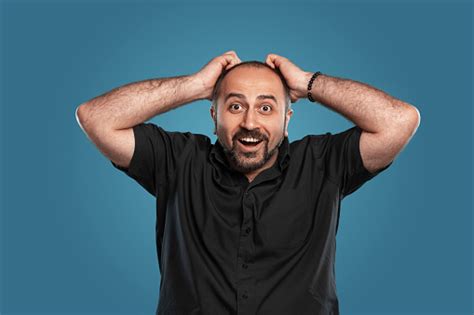 수염을 가진 브루넷 중년 남성의 클로즈업 초상화 검은 색 티셔츠를 입고 파란색 배경에 포즈를 취하다 Mental Wellbeing에 대한 스톡 사진 및 기타 이미지 Istock