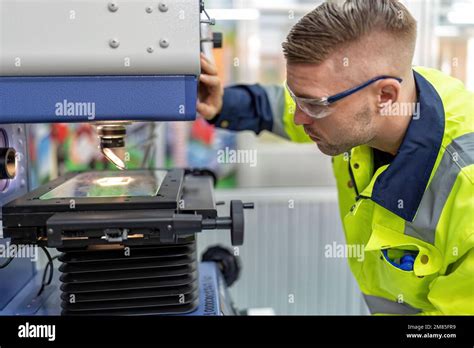 Engineer Sitting In Robot Fabrication Room Use Measuring Microscope