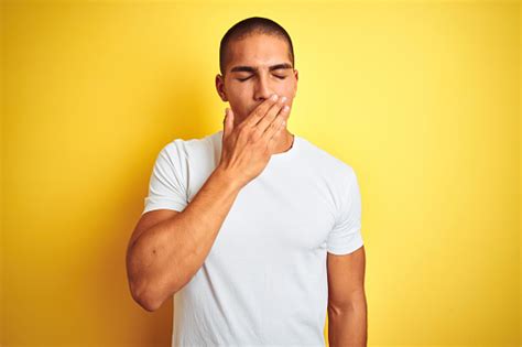 노란색 고립 된 배경 지루 한 하품 손으로 입을 덮는 피곤 한 위에 캐주얼 흰색 티셔츠를 입고 젊은 백인 남자 불안과 졸음 T 셔츠에 대한 스톡 사진 및 기타 이미지