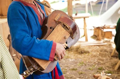 Premium Photo Man Playing The Ancient Stringed Instrument Reconstruction Of Ancient Times