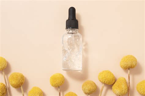 스킨케어를 위한 꽃 추출물이 함유된 세럼 자연 화장품 유리 병에 피펫과 Craspedia 꽃 베이지 색 배경 얼굴과 몸 관리 온천장 개념 개념에 대한 스톡 사진 및 기타