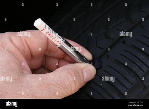 A Mechanic Uses A Depth Gauge To Measure The Depth Of A Tire Tread For Safety Stock Photo Alamy