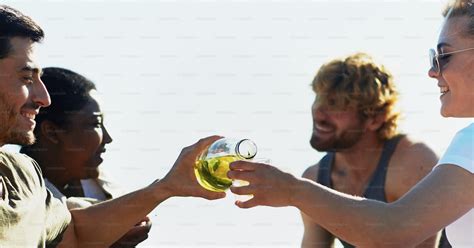 해변에서 피크닉을 하는 동안 레모네이드를 병에서 여자의 유리잔에 붓는 남자 중 한 명 사진 Unsplash의 러시아 이미지