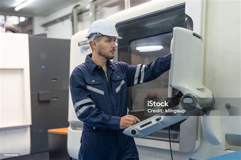 공장에서 작동하는 컴퓨터 제어판 Cnc 기계를 사용하는 남성 엔지니어 제복을 입은 남자 기술자와 헬멧 안전 작업장 중금속 산업