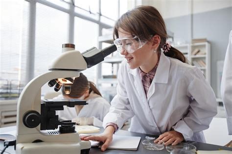 Premium Photo Excited Girl Looking In Microscope In Science Lab