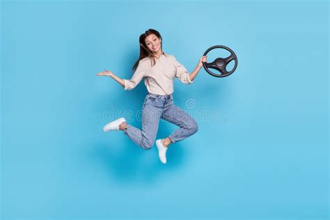 Full Length Photo Of Unsure Lady Jump Drive Wear Shirt Jeans Shoes Isolated On Blue Color