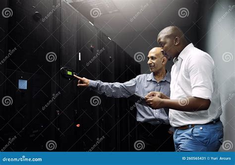 Essential Equipment Two It Technicians Using A Digital Tablet While