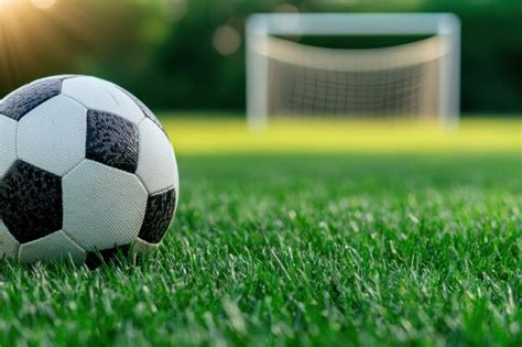 A Set Of Football Gear Including A Ball Cleats And Shin Guards Placed On Freshly Cut Grass With