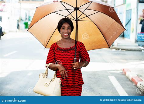 Красивая зрелая женщина с зонтиком на покупки улыбаясь Стоковое Изображение изображение