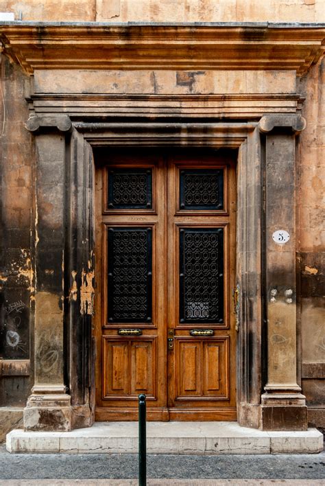 회색 콘크리트 건물에 갈색 나무 문 사진 Unsplash의 무료 프란시아 이미지