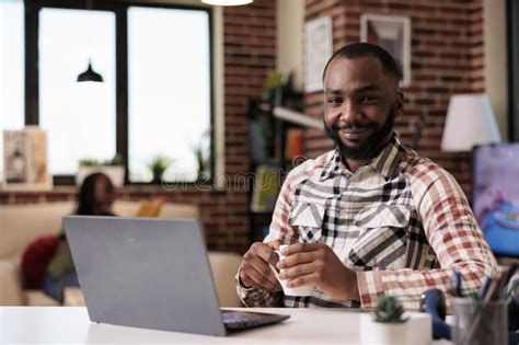Portrait Of African American Programmer Smiling At Camera While Holding