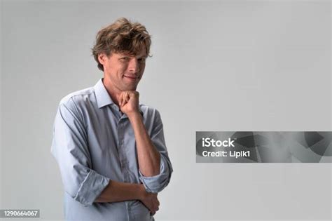 파란 셔츠를 입은 잘생긴 남자의 초상화가 주먹에 턱을 기대었다 잘 생긴 자신감 백인 착용 정장 서 교차 팔 고립 된 흰색 배경 남성에 대한 스톡 사진 및 기타 이미지