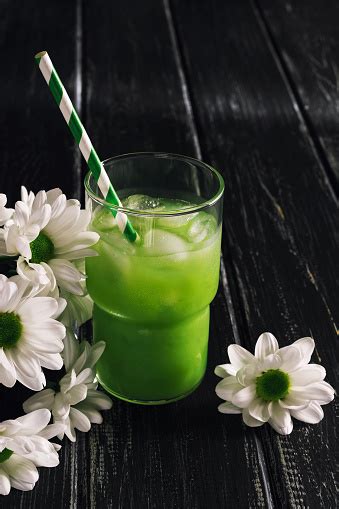 A 밀 짚과 흰색 꽃 줄무늬 얼음 녹색 음료 상쾌 나무 나무 테이블에 녹색 주스입니다 여름 콜드 칵테일입니다 텍스트에 대 한 장소입니다 0명에 대한 스톡 사진 및 기타