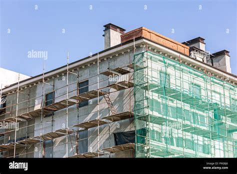Facade Of A Renovated Building Scaffolding With Green Protective Net Stock Photo Alamy