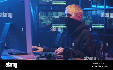 Caucasian Woman Hacker With Blond Short Hair And Masked Face Sitting In Dark Stock Video Footage