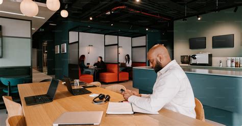 테이블에 앉아 노트북으로 작업하는 남자 사진 Unsplash의 사무직 이미지