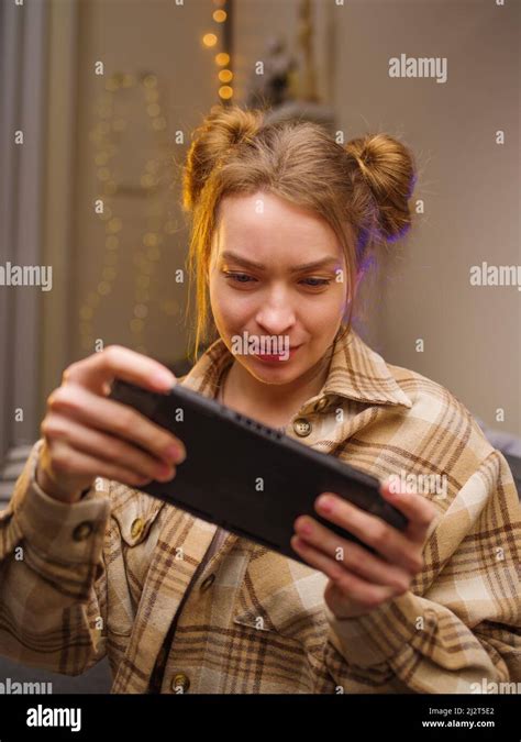 A Teenager Girl Plays A Mobile Game On A Portable Game Console Close