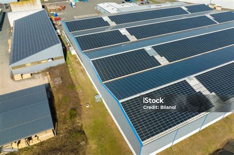 녹색 생태 전기를 생산하기 위해 산업 건물 지붕에 장착 된 푸른 태양광 태양 전지 판넬의 공중 보기 지속 가능한 에너지 개념의 생산 건물 외관에 대한 스톡 사진 및 기타