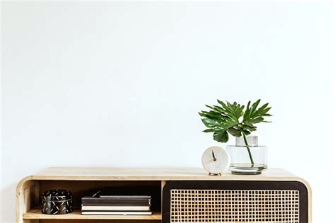 세련된 Commode 꽃병에 열대 잎 책 흰색 시계와 우아한 액세서리와 스칸디나비아 아파트에서 거실의 인테리어 디자인 현대적인 홈 장식 템플릿 공간을 복사합니다 흰색