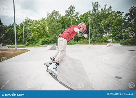 Closeup Shot Of An Inline Skater In A Skating Rink Practicing Moves With Trees In The Background