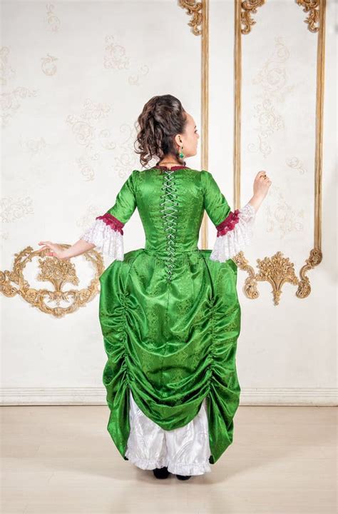 Beautiful Woman In Rococo Style Medieval Dress Standing Near Wall Back