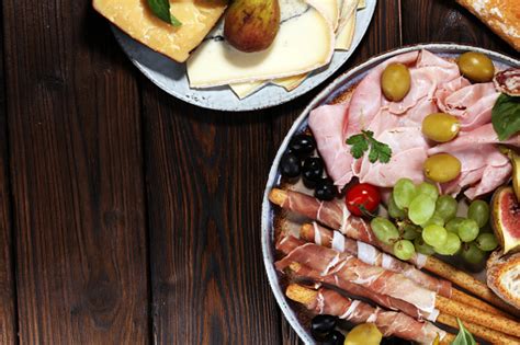 이탈리아 전채 와인 간식 세트입니다 치즈 지중해 올리브 피 클 햄 디 파 르 마 살라미 고 그런 지 검은 배경 위에 안경에 와인