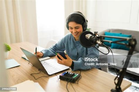 오디오 콘텐츠를 녹음하고 헤드폰을 착용하고 홈 스튜디오 환경에서 전문 마이크와 노트북을 사용하면서 웃는 귀여운 팟캐스터 20 29세에 대한 스톡 사진 및 기타 이미지