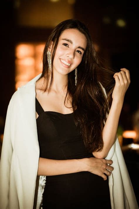 실내에서 웃고 있는 이브닝 드레스를 입은 우아한 여성 · 무료 스톡 사진