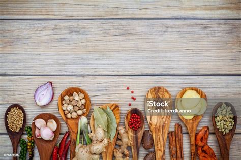 향신료와 나무 숟가락에 허브의 다양 한 평평 하다 향신료 재료 고추 고추 옥수수 마늘 백 리 향 오 레가 노 계 피 스타 아니 스 육 두 구 메이 스 세이 지와 나무 바탕에