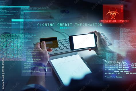 Cyber Security Hacking And Fraud With A Computer Hacker Holding A Credit Card And Phone While