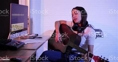 기타를 들고 노래를 작곡하는 젊은 아시아 여성 여자는 어쿠스틱 기타를 연주하고 가사 노래를 생각한다 여성 작곡가 음악가 개념