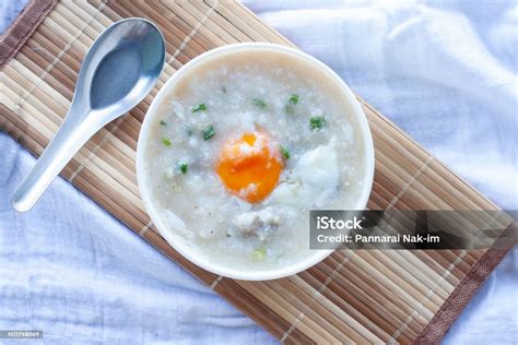 흰 그릇에 달걀을 넣고 나무 테이블에 숟가락을 곁들인 쌀죽 또는 콩지의 꼭대기 전망 간 내장류에 대한 스톡 사진 및 기타 이미지 간 내장류 건강한 생활방식 고급 요리
