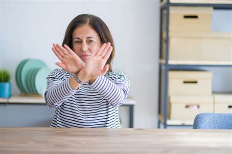 중년 노인 여성 집에서 테이블에 앉아 거부 표정 교차 팔과 손바닥 을 하고 부정적인 기호 화가 얼굴 가정 생활에 대한 스톡 사진 및 기타 이미지 Istock
