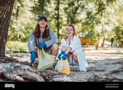 Man and Woman picking up trash from the park. They collecting the litter in garbage bag Stock ...