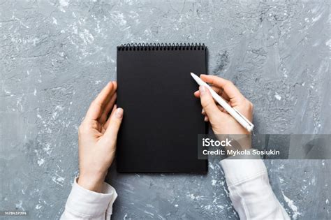공책에 연필을 쓰고 있는 여자 손 사무실 테이블에서 일하는 여자 연필과 스케치북을 들고 있는 여성 손 모형 컨셉 고정됨에 대한